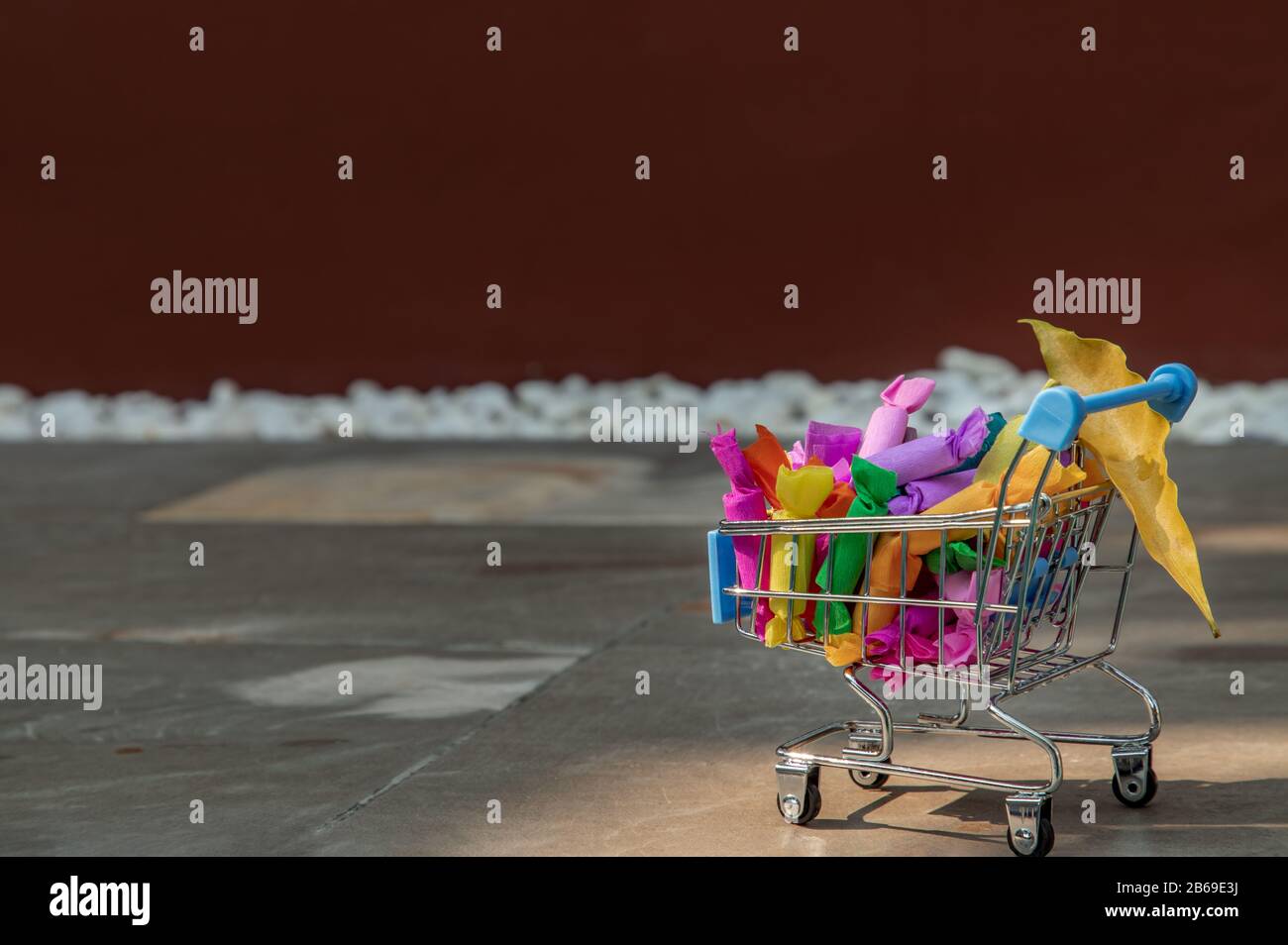 Colorful Jelly toffee in shopping cart on tiles floor. Giving happiness ...
