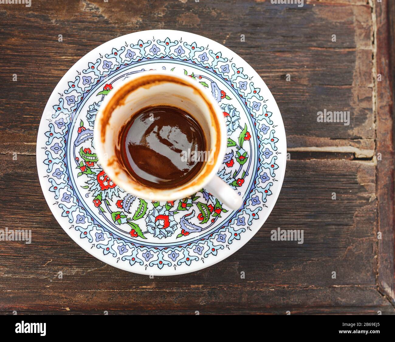 Almost empty cup of Turkish coffee with brown grounds, traditionally ...
