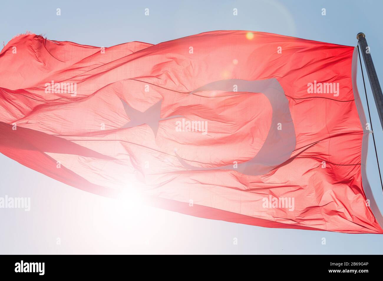 National Flag of Turkey over Blue Sky with sun flare Stock Photo - Alamy