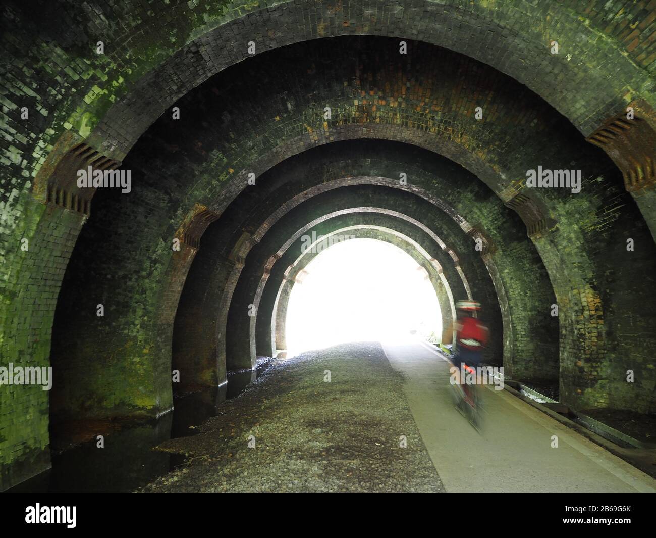 cyclist riding through an old railway tunnel on a cycle path Stock ...