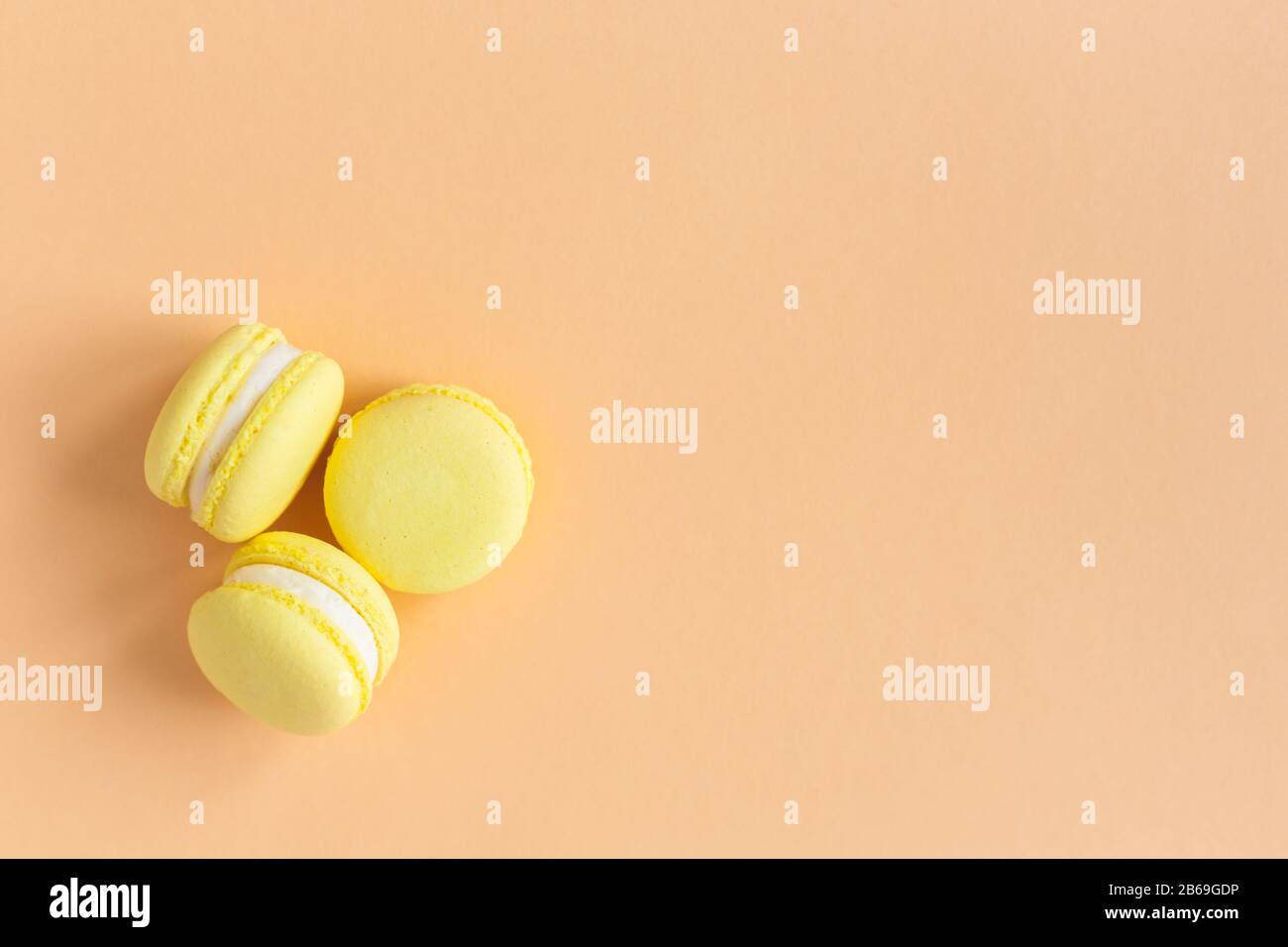 Yellow french macarons on a peach pastel background. Lemon macarons ...