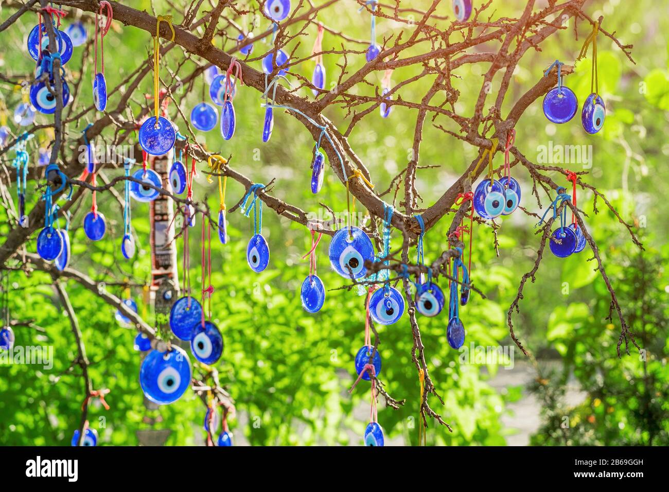 Evil eye charms hang on a green tree at summer in Cappadocia, Turkey ...