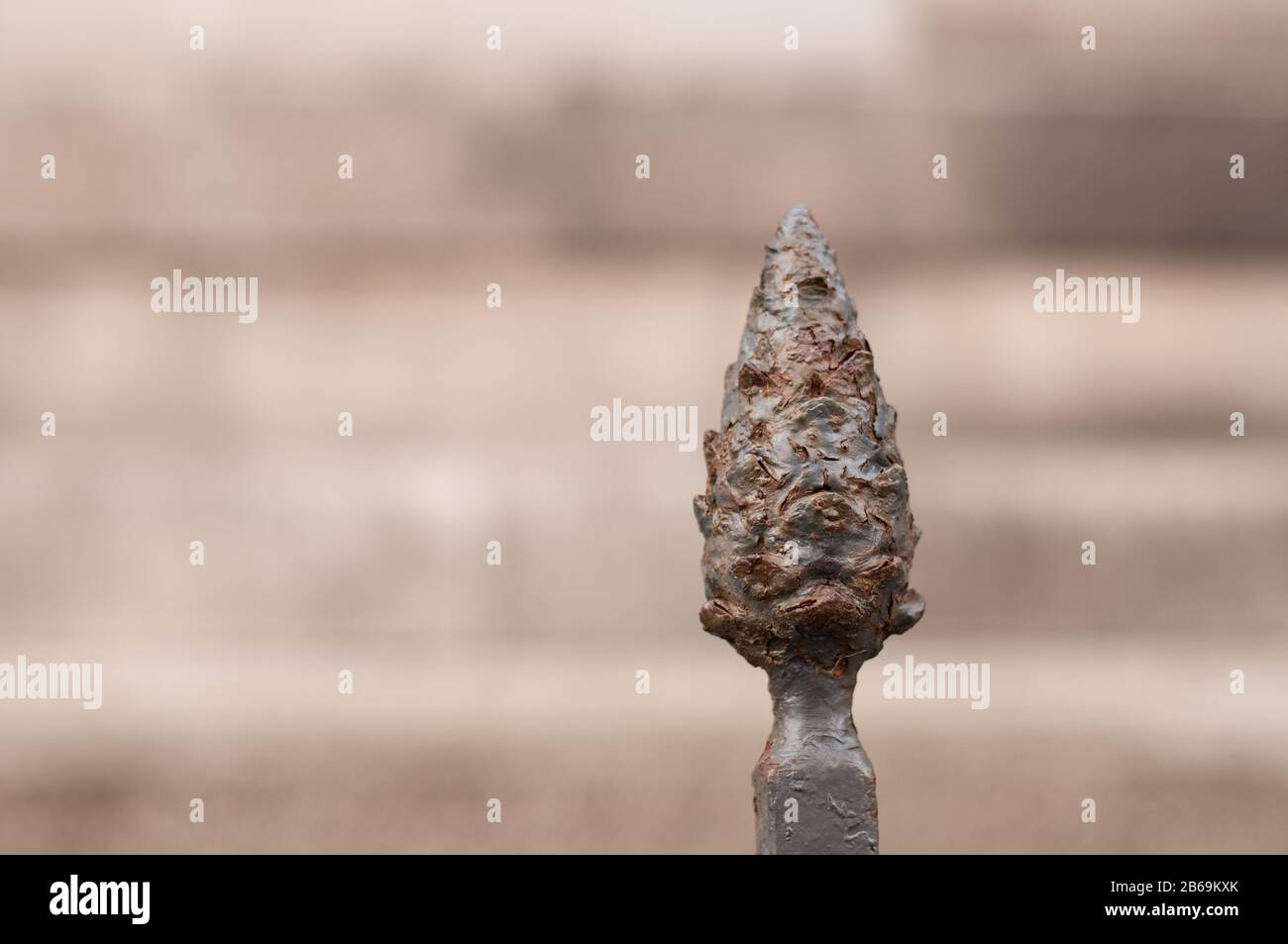 close-up of a wrought iron post head in cone shape in front of historic ...