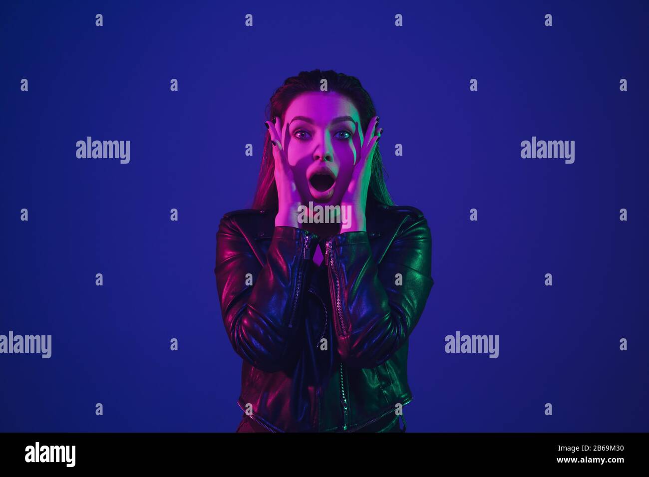 Shocked, scared. Caucasian woman's portrait isolated on blue studio ...