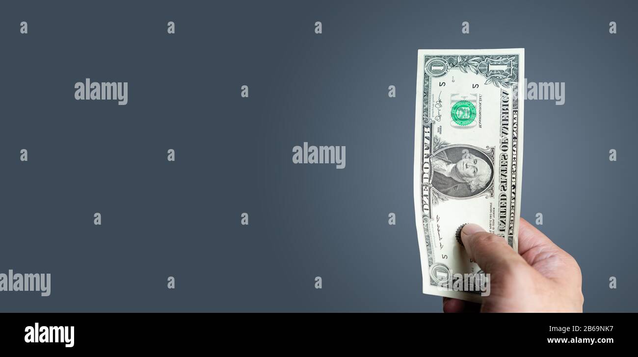 Young man holding small dollar bill Stock Photo - Alamy