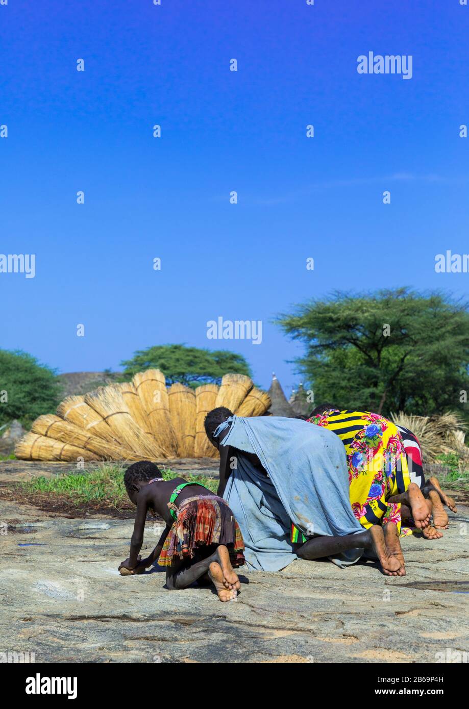 Larim tribe girls grinding Sorghum grains in holes in a rock, Boya ...