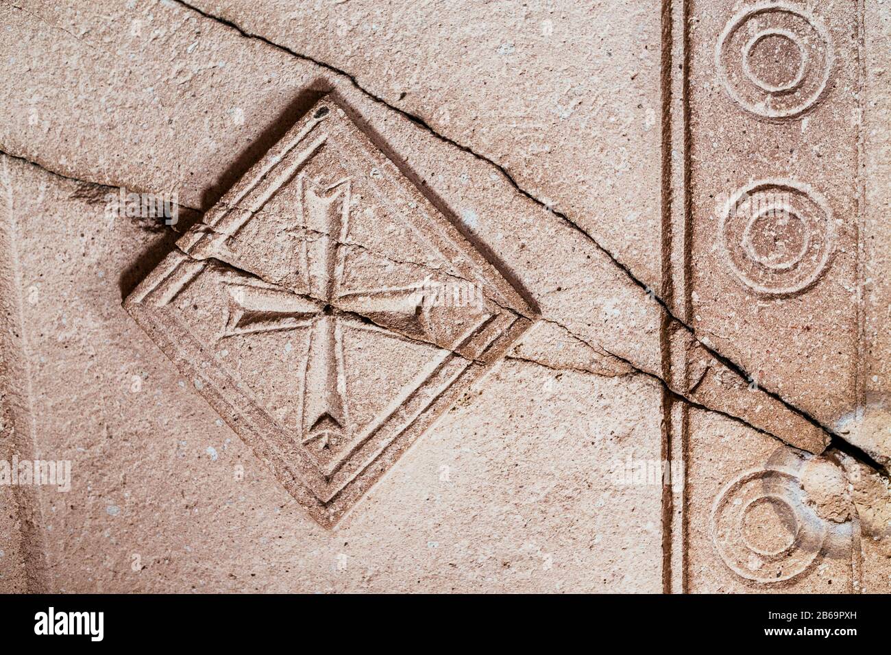Orthodox ancient Christian cross carved into the wall with crack inside ...