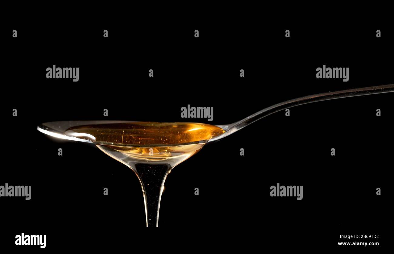 Natural Honey syrup on the spoon Stock Photo - Alamy