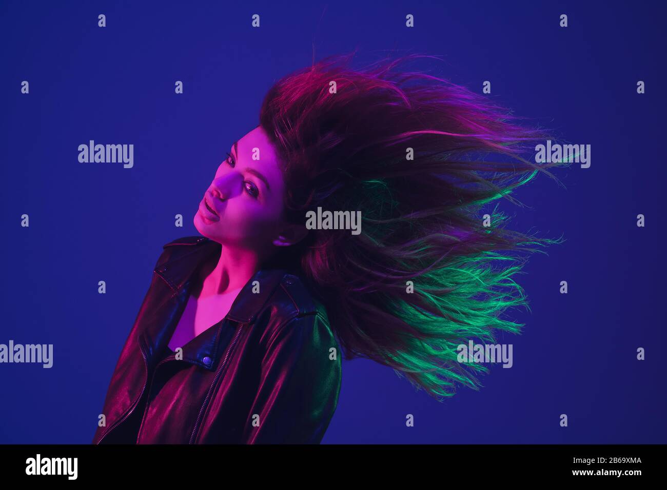 Dancing, hairs flying. Caucasian woman's portrait isolated on blue ...