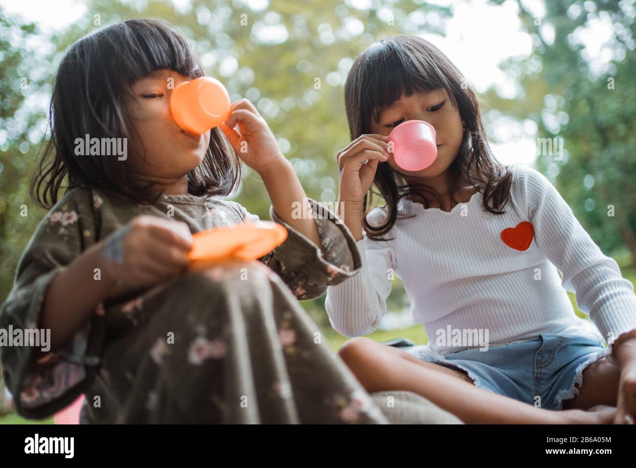 two little girls playing cup toys for drinking when enjoy playing ...