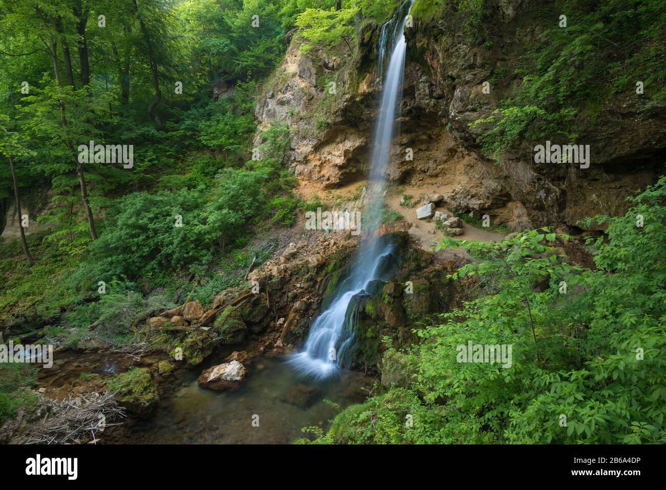 Waterfall surrounded with green trees. This handmade waterfall is situated in Lillafured park ...