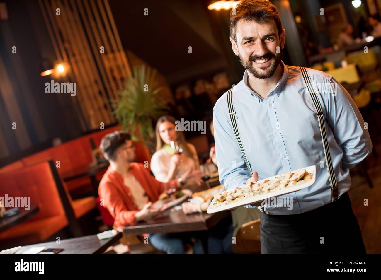 Portrait of the waiter carries dishes in modern restaurant Stock Photo ...