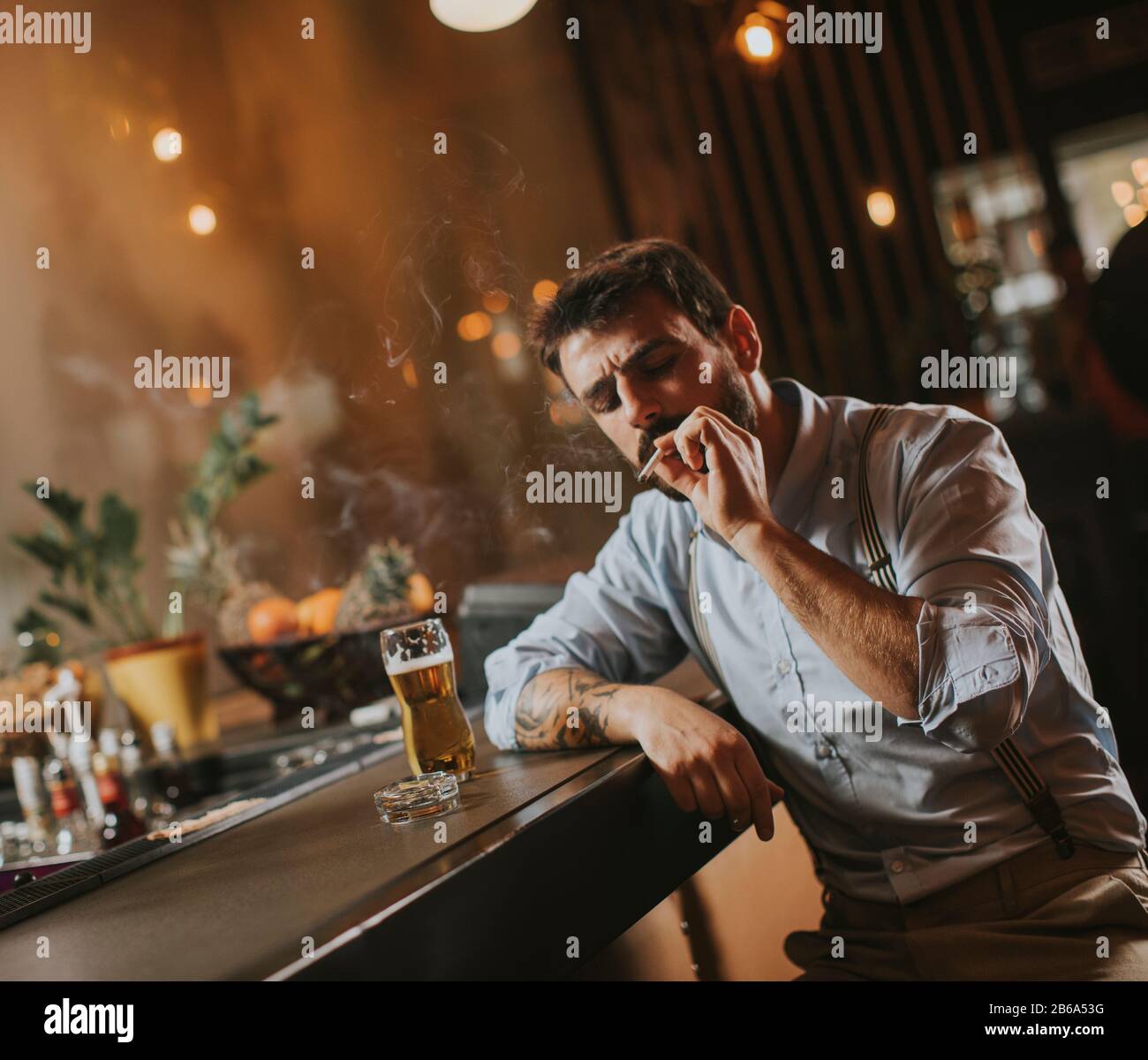 Man drinking beer and smoking cigarette at pub in the night Stock Photo ...
