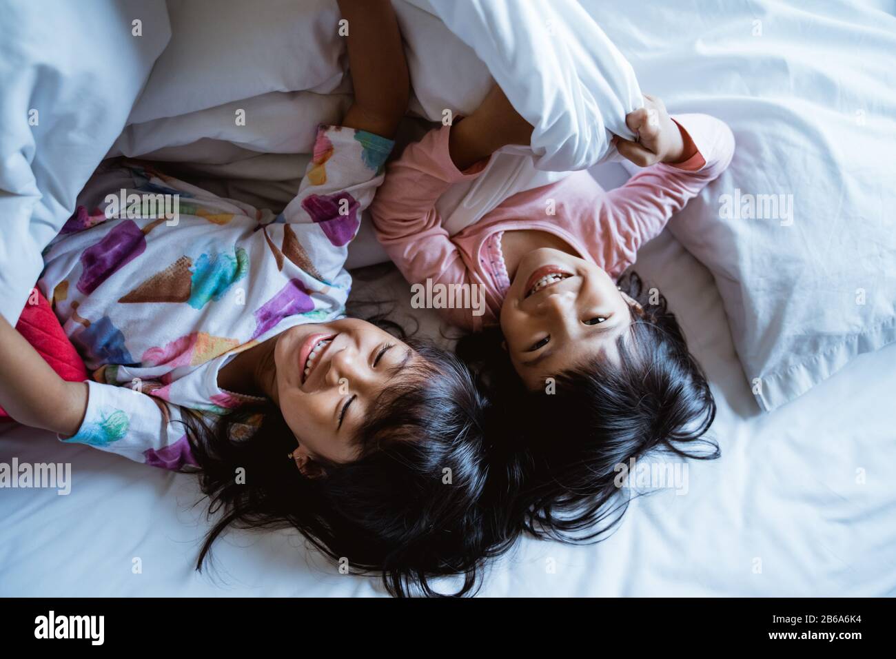 two children play and laugh in bed when they wake up Stock Photo - Alamy