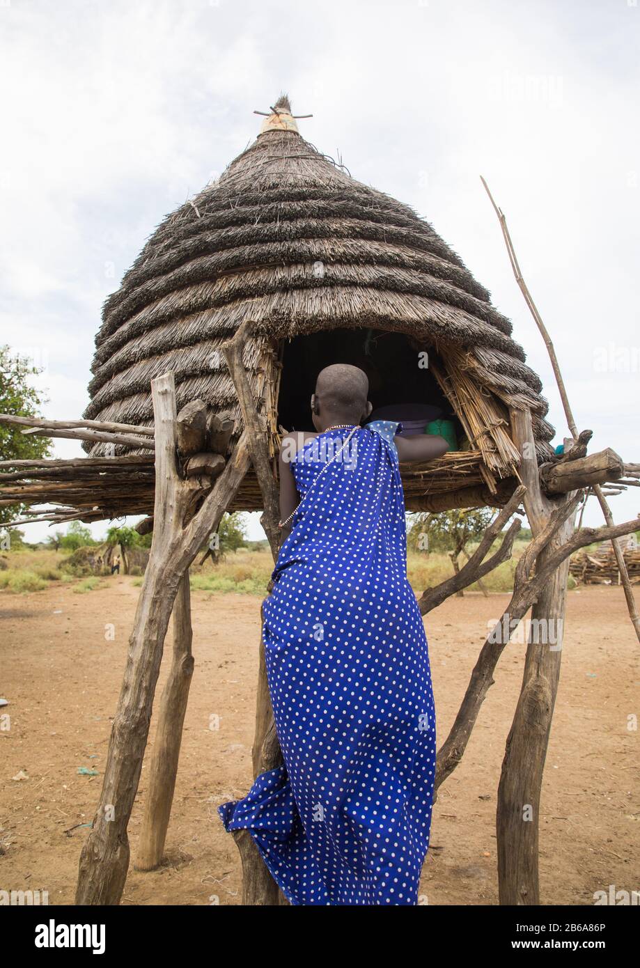 Toposa tribe girl climbing in a granary in a village, Namorunyang State ...