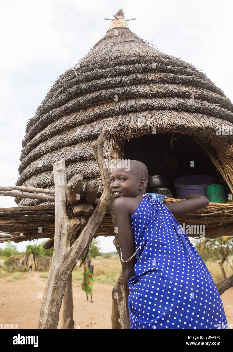 Toposa tribe girl climbing in a granary in a village, Namorunyang State ...