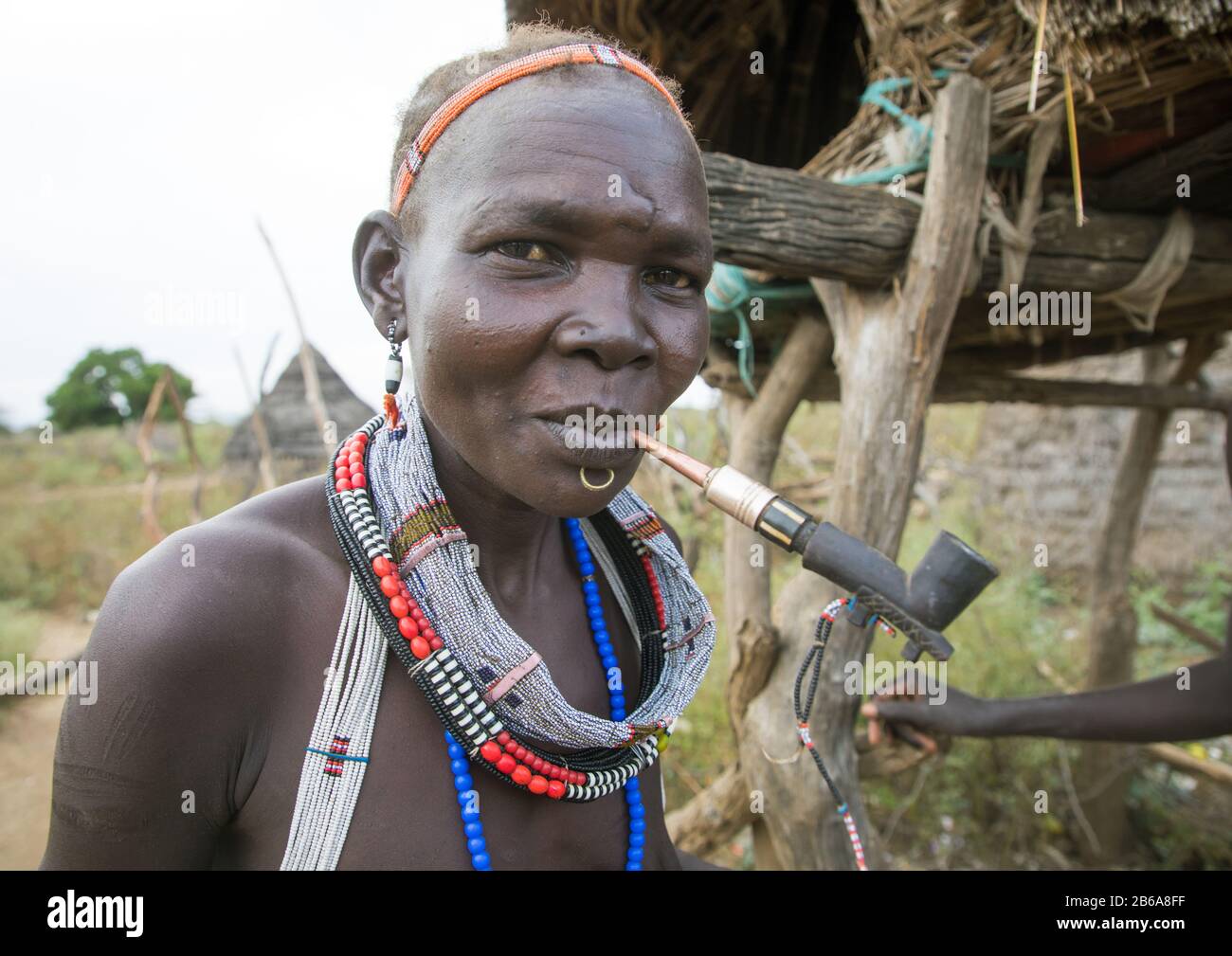 Toposa tribe woman smoking pipe in a village, Namorunyang State ...