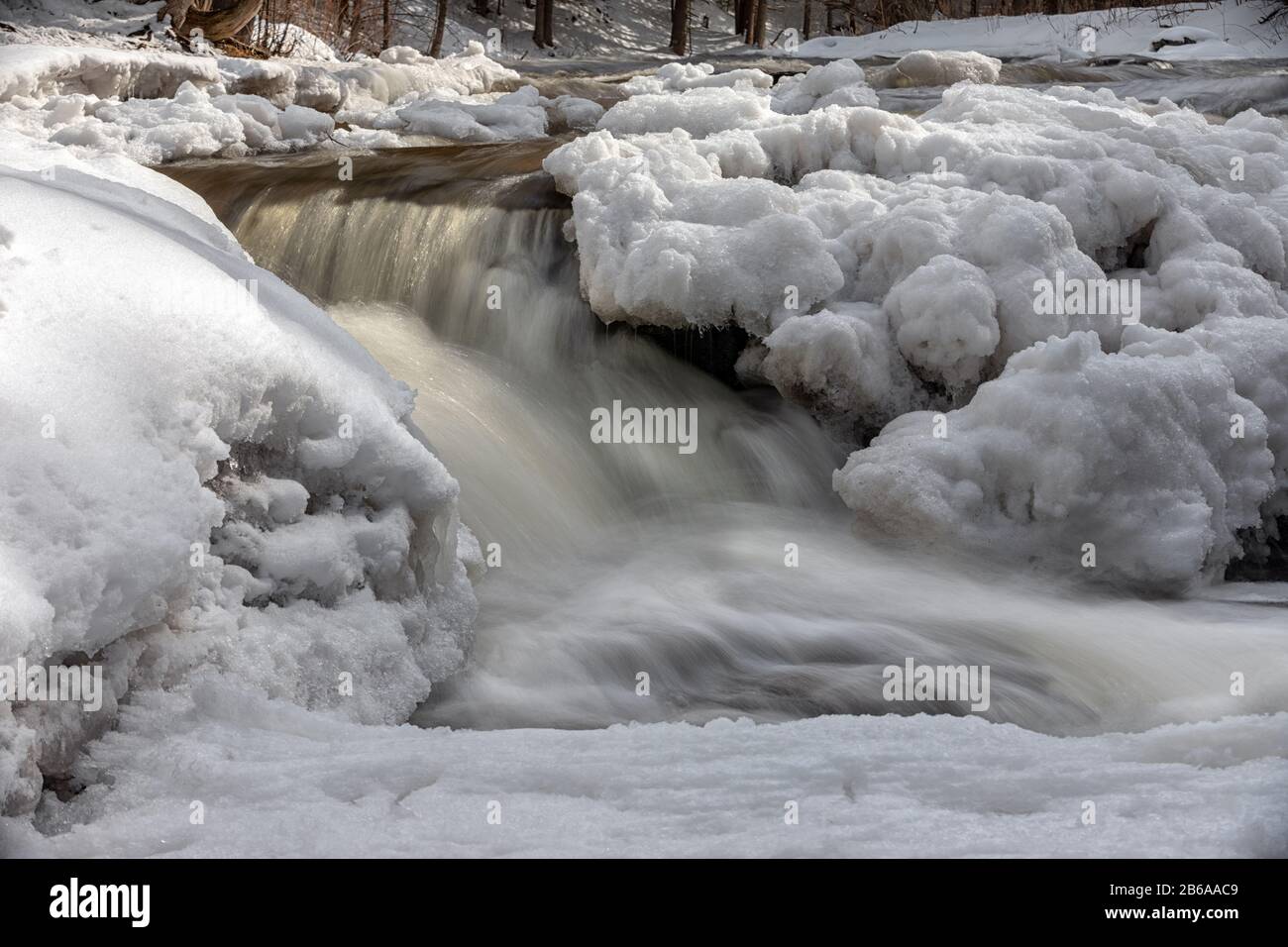 Ocqueoc Falls flows through snow and ice under winter conditions near ...