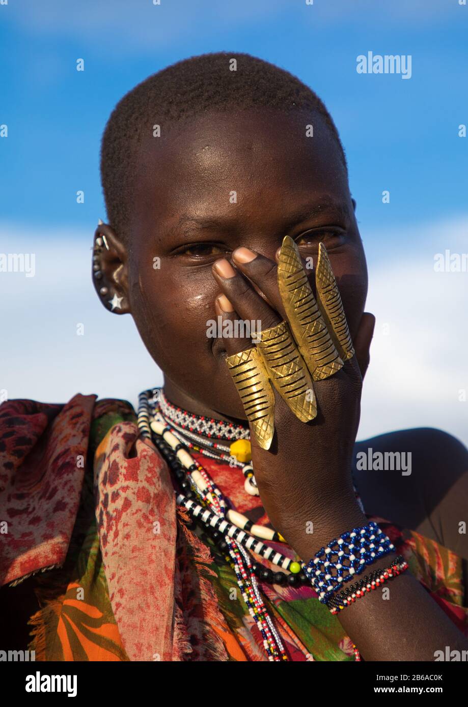 Portrait of a shy Toposa tribe woman with big rings on the hand ...