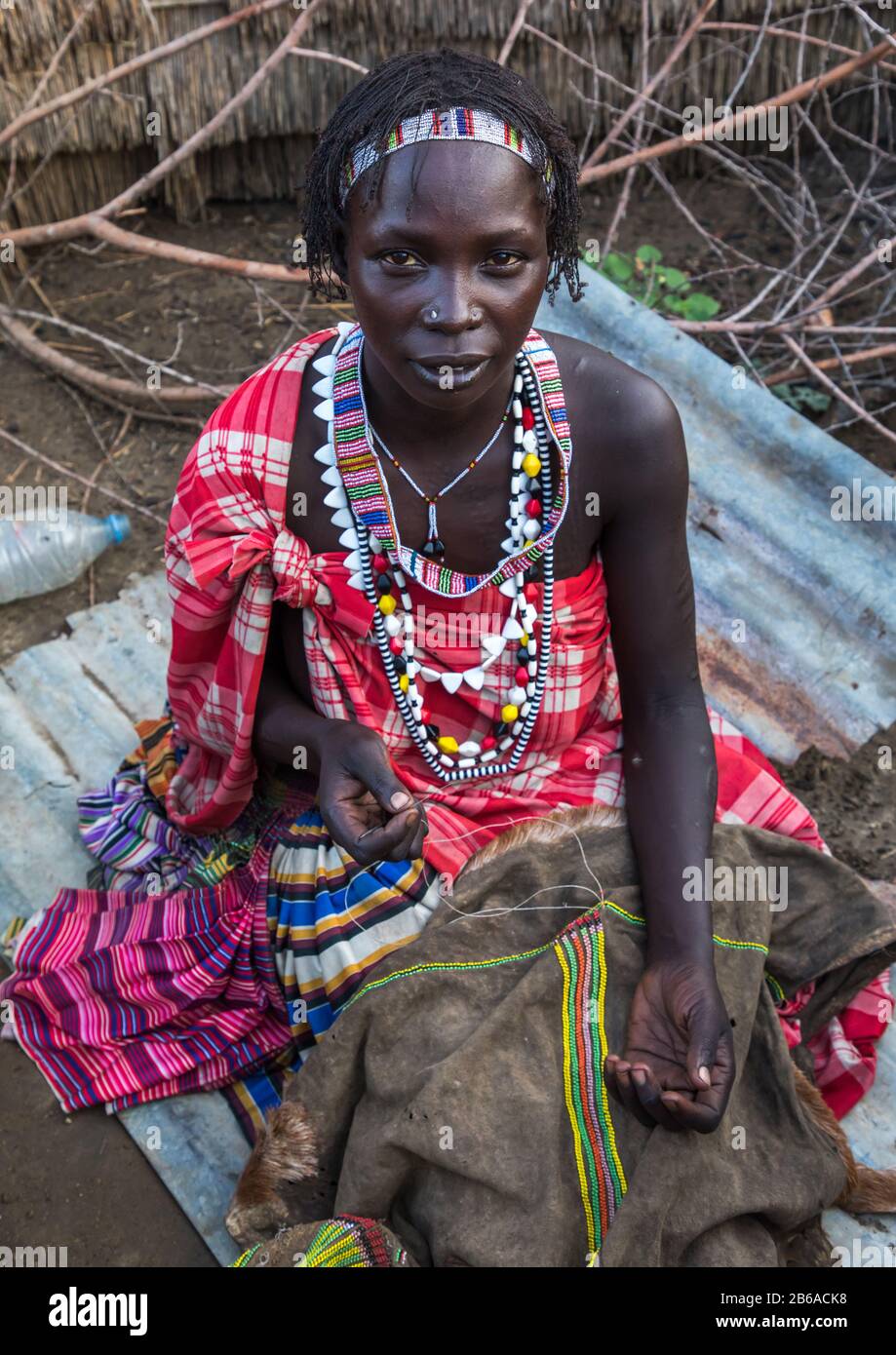 Portrait of a Toposa tribe woman sewing a skirt, Namorunyang State ...