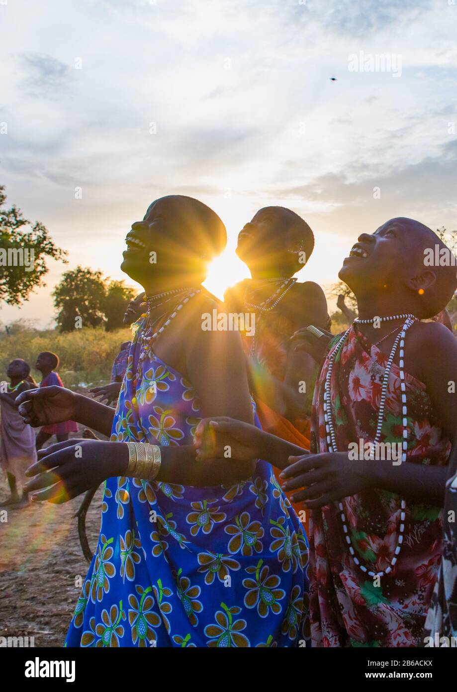 Toposa tribe women in traditional clothing looking at the sky ...