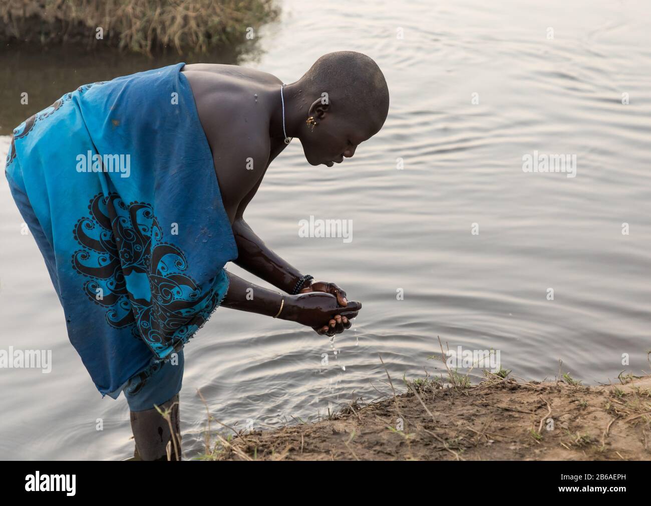 Mundari tribe women washing her hands in river Nile, Central Equatoria ...