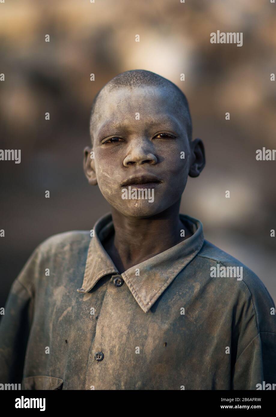 Portrait of a Mundari tribe boy covered in ash to repel flies and mosquitoes in a cattle camp ...