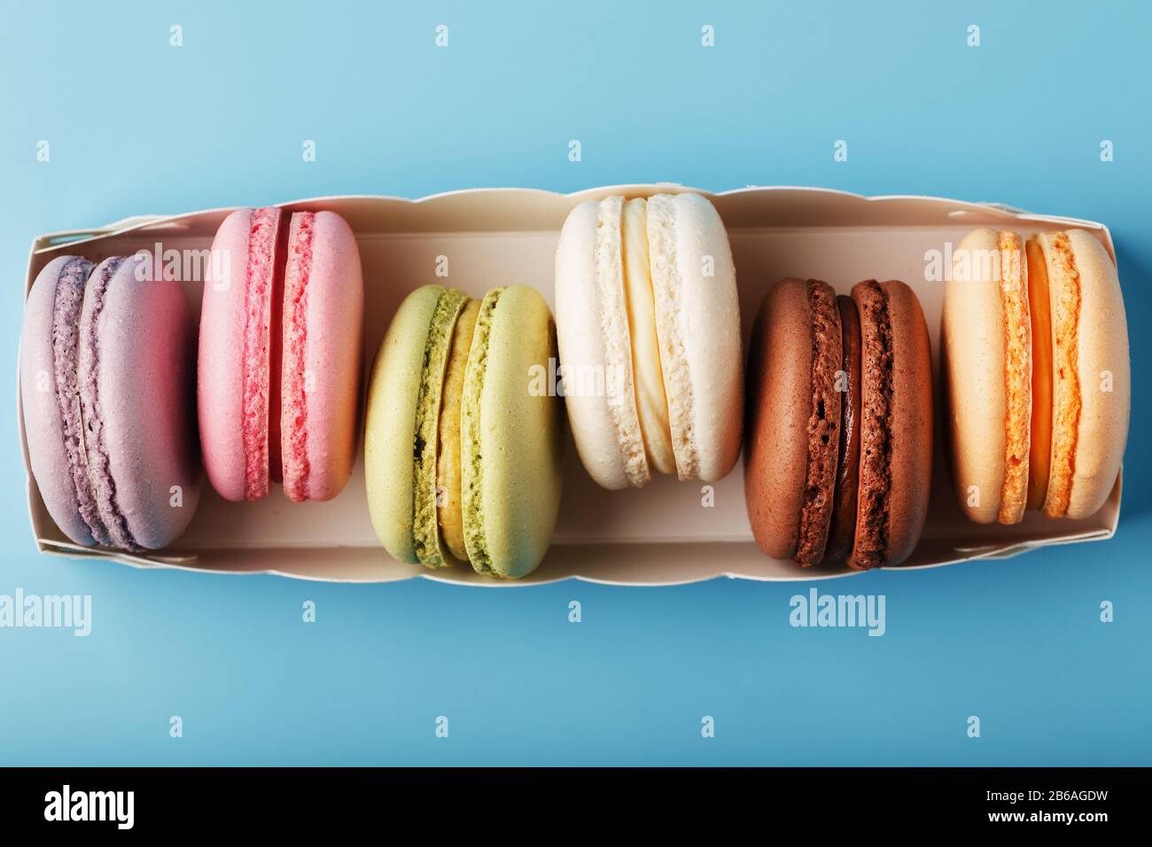 Multicolored French macaroni macaroni cookies in a white box on a blue ...