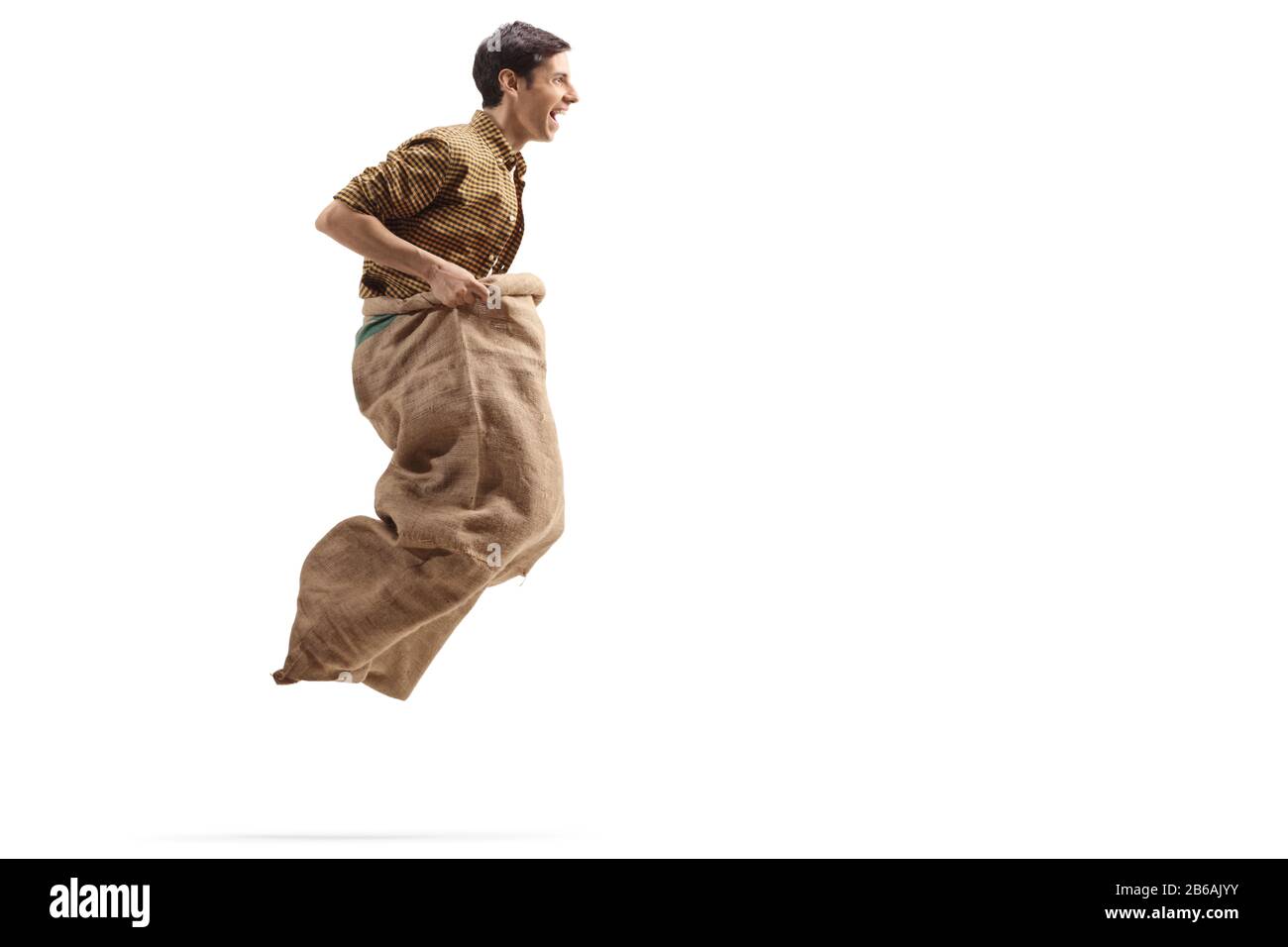 Profile shot of a young man jumping with a sack isolated on white ...
