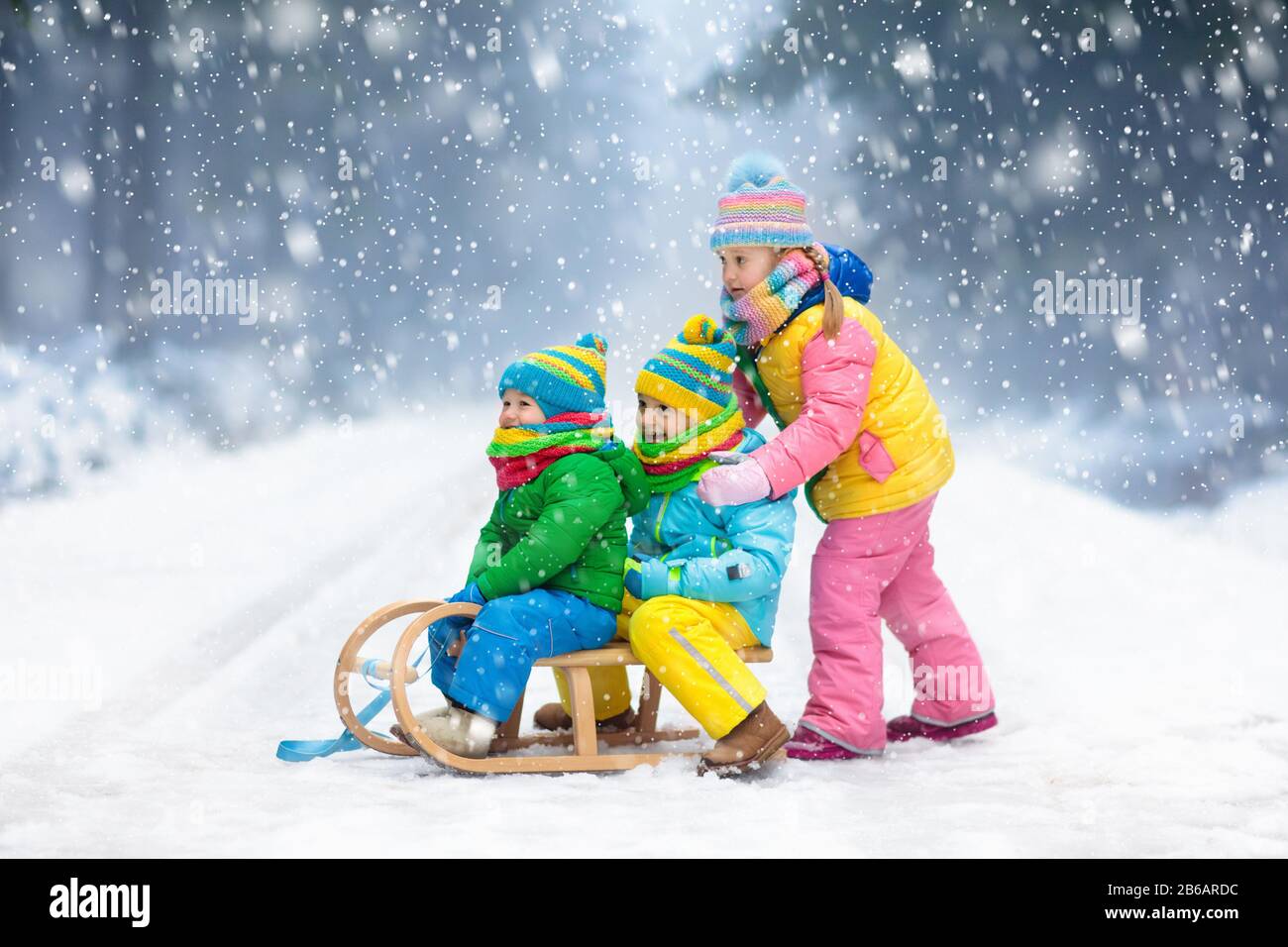Little girl and boy enjoying sleigh ride. Child sledding. Toddler kid ...