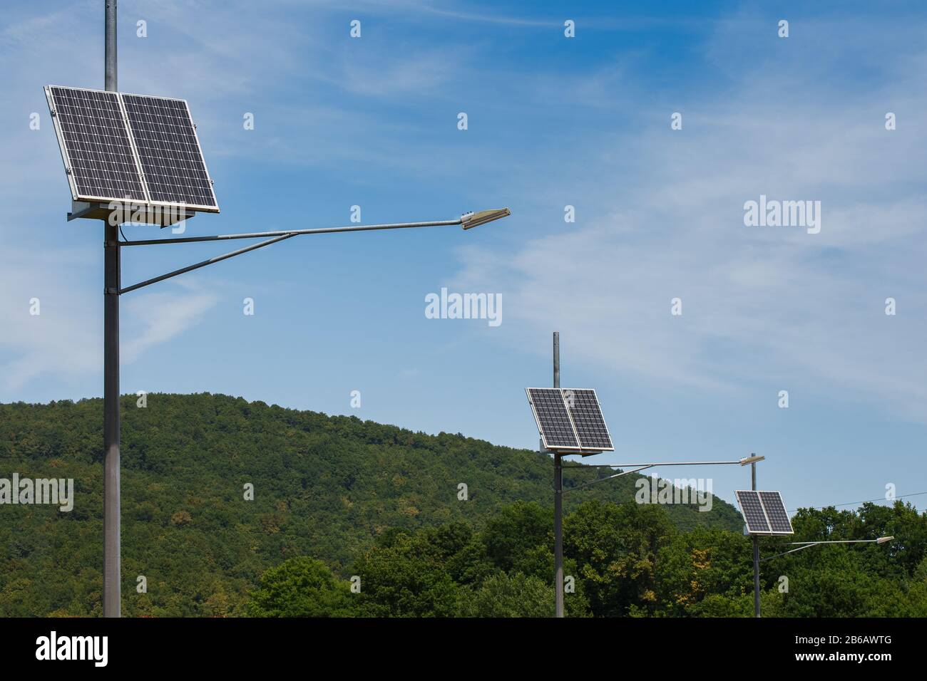 Public urban light with a solar panel working on a blue sky with clouds ...