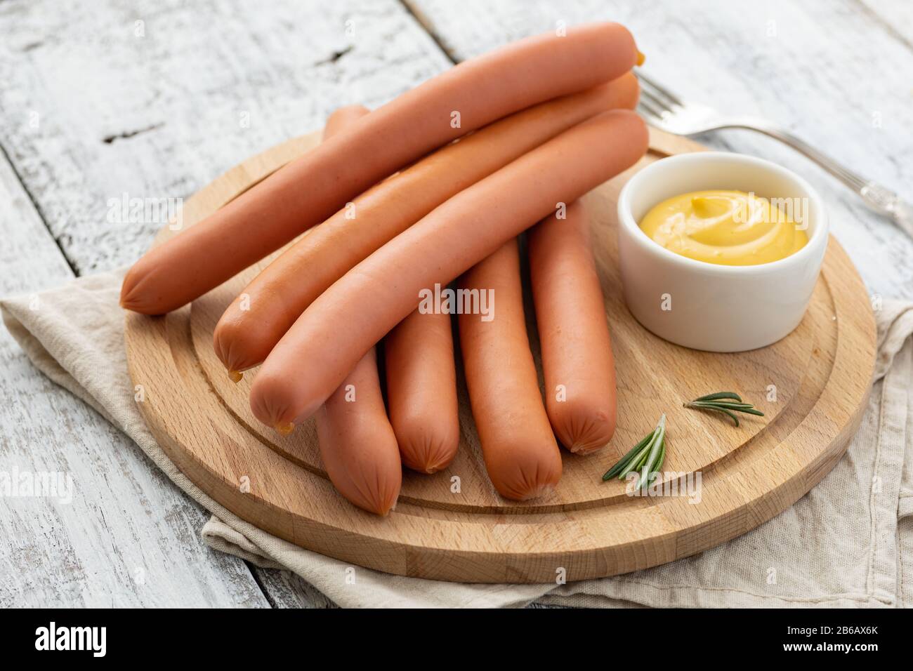 Raw frankfurter sausages with mustard on cutting board Stock Photo - Alamy