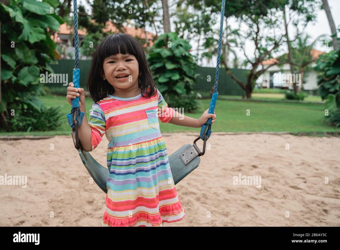 the daughter cries while playing her own swing on the playground Stock ...