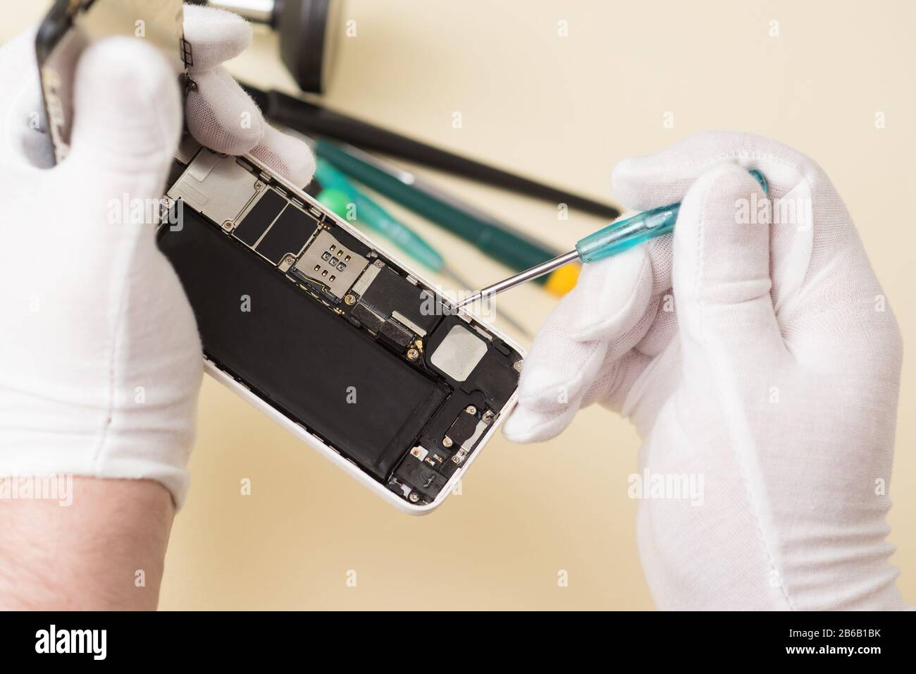 Profession repairman of digital electronics. Hands in white gloves with ...