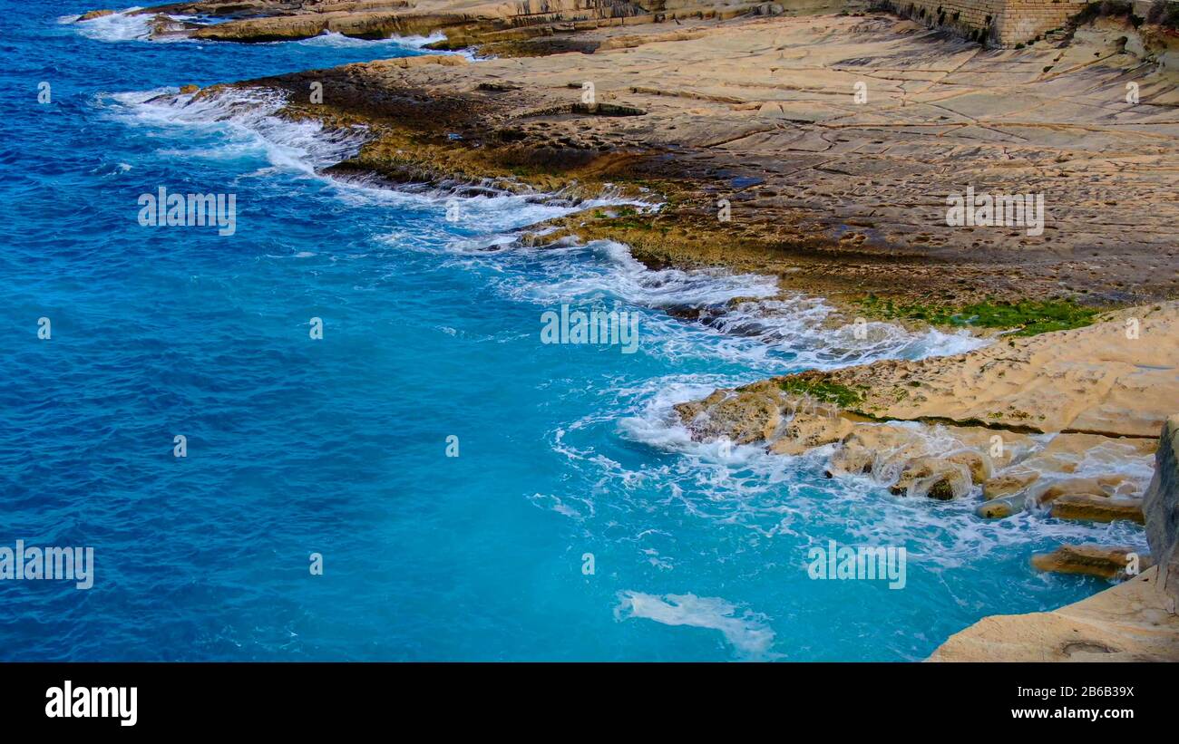 Wonderful turqouise blue ocean water hitting against the rocks - top ...