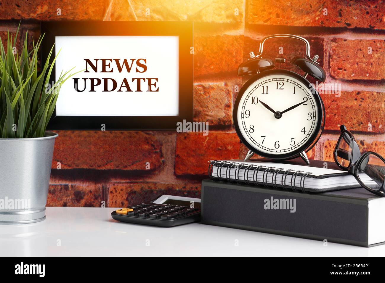 NEWS UPDATE text with alarm clock, books and vase on brick background ...