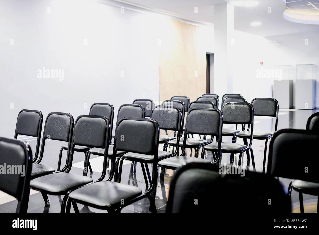 Black chairs stand in even rows in the classroom. Room for lectures ...