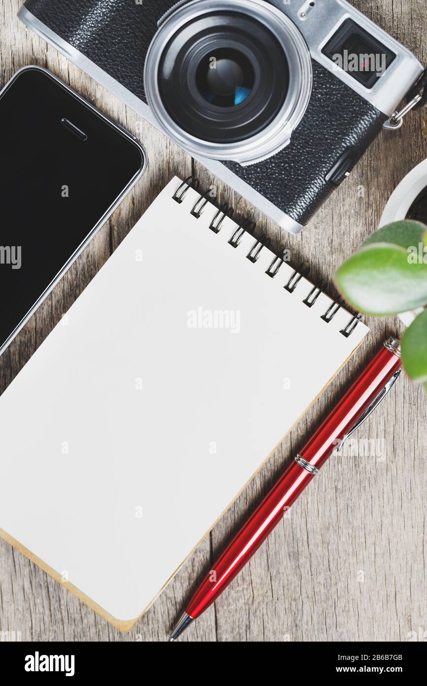 Classic camera with blank notepad page and red pen on gray wooden ...
