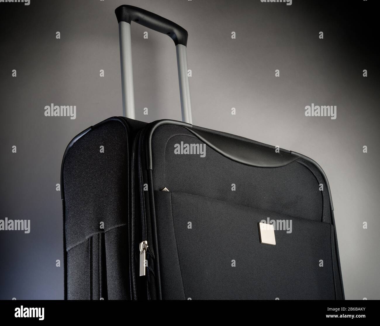 A black suitcase with two wheels and a pulling handle Stock Photo - Alamy