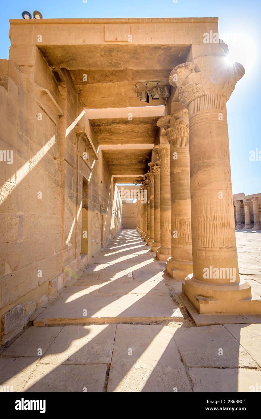 covered corridor with Lotus columns on one side, and sharp shadows on ...