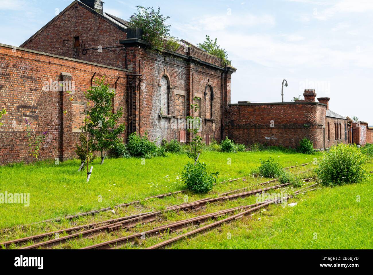 derelict building and overgrown train tracks at Birkenhead Docks Wirral ...