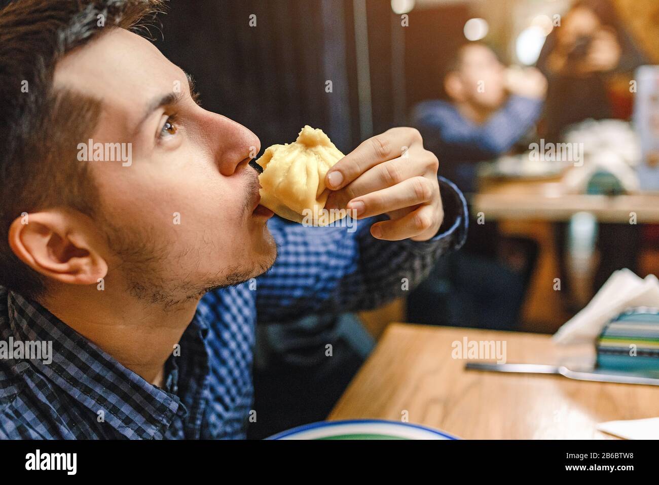 Man eating in georgian restaurant national snack Khinkali, that is a ...