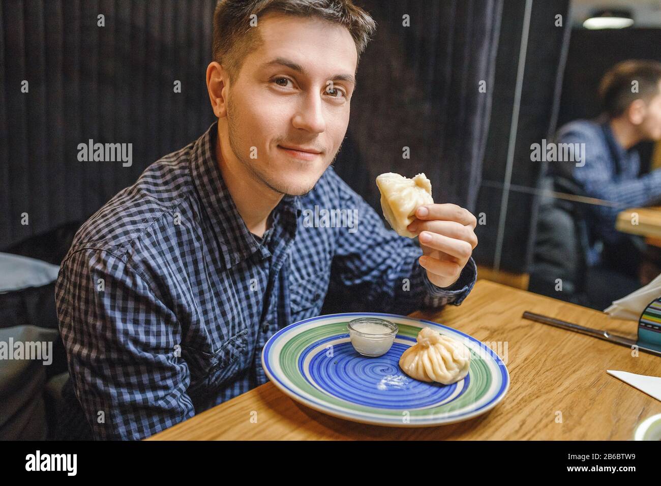 Man eating in georgian restaurant national snack Khinkali, that is a ...