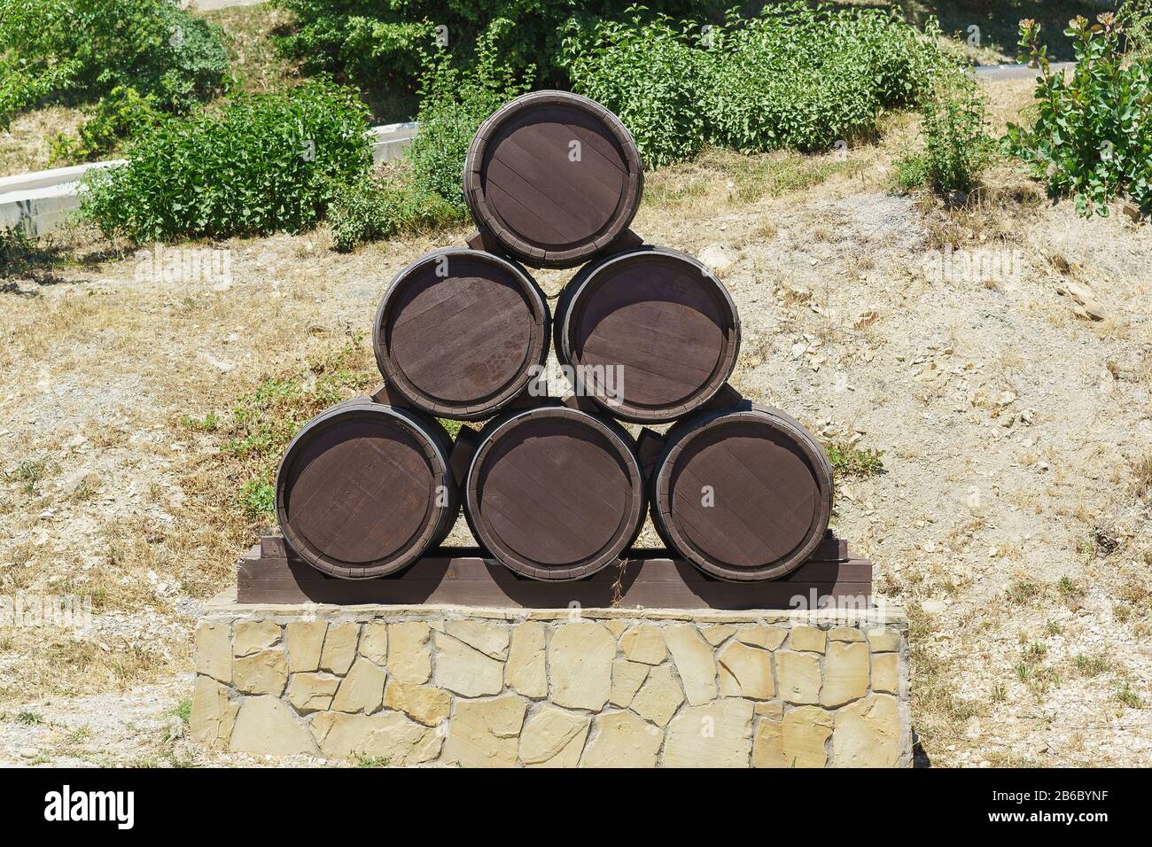 Six wine barrels, made up of a pyramid on a pedestal of stone. The wine ...