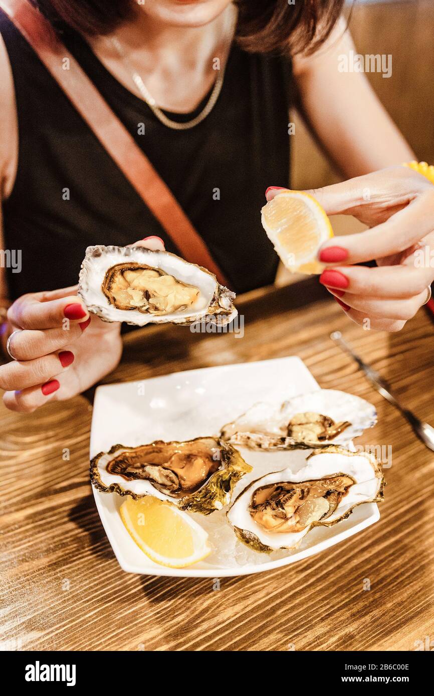 Woman eating oysters and shellfish in restaurant. Delicious and ...