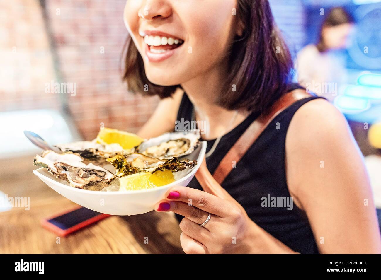 Woman eating oysters and shellfish in restaurant. Delicious and ...