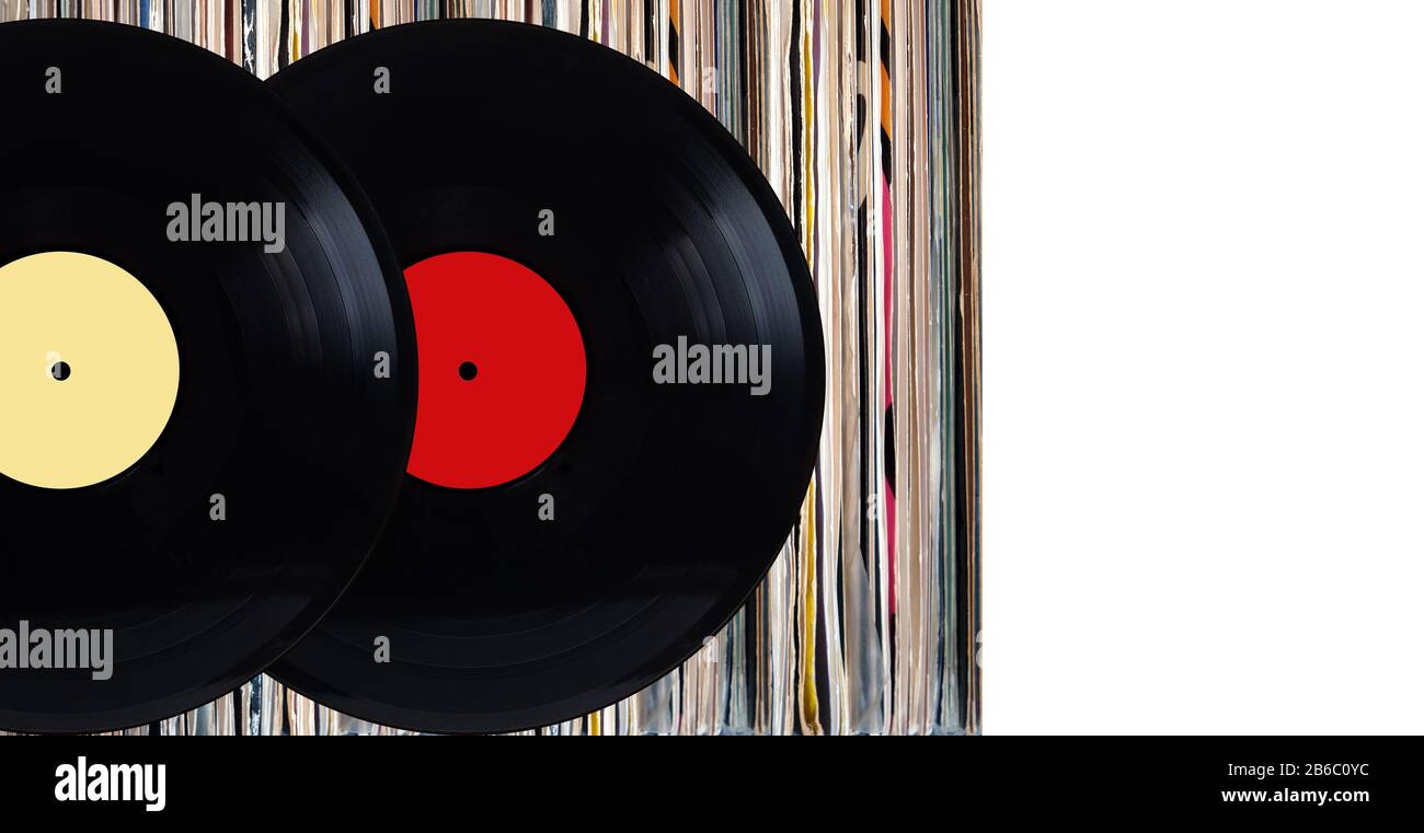 Two black vinyl records with color labels in front of shelf of many ...