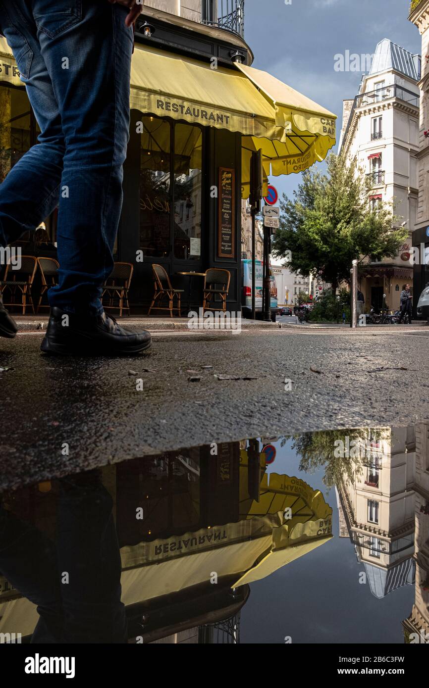 Paris, France - 08 June 2019: Man crossing a street in Paris after a ...