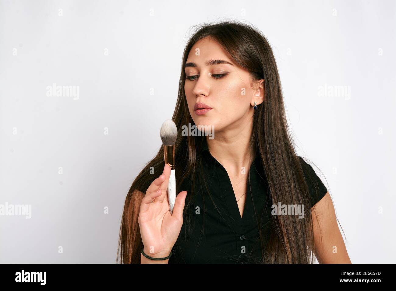 Professional makeup artist poses with the makeup brush and makeup ...