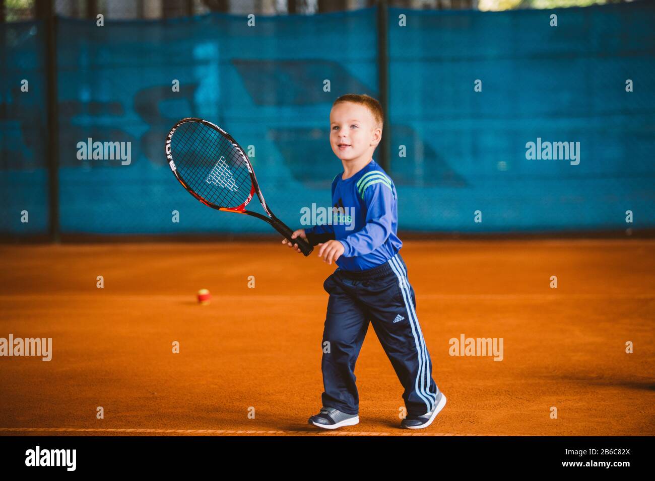 Child playing tennis on outdoor court. September 20, 2016. Ukraine ...